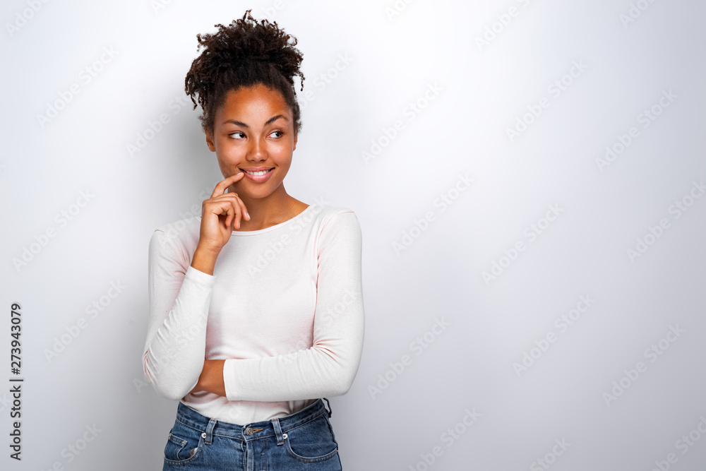 Studio portrait of a playfully pose girl touching herself face by index ...