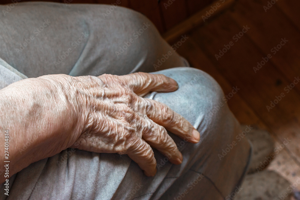 wrinkled hand of an elderly woman with clearly visible veins reaching ...