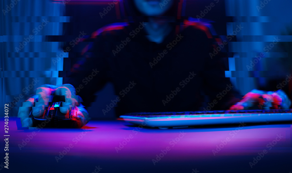 Hacker in the hood working with computer typing text in dark room ...