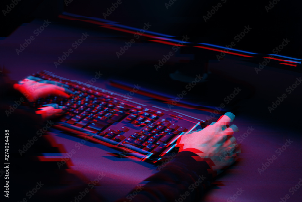 Hacker in the hood working with computer typing text in dark room ...