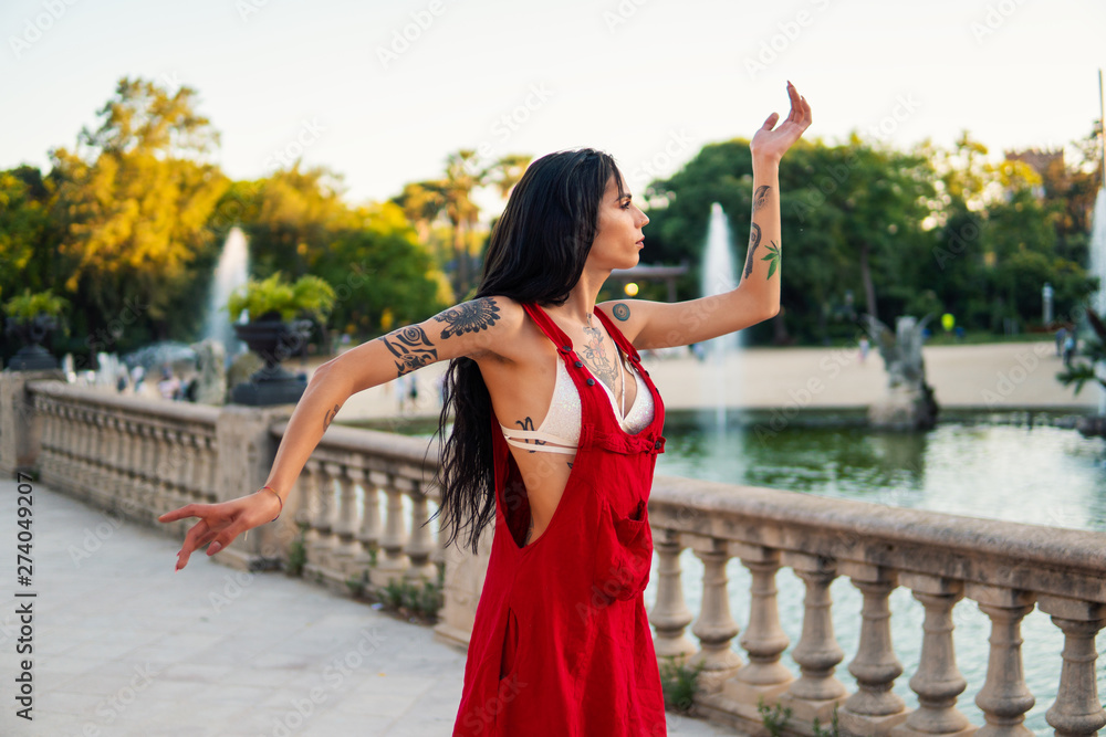tattooed transgender model is dancing in the green park. Emotional ...