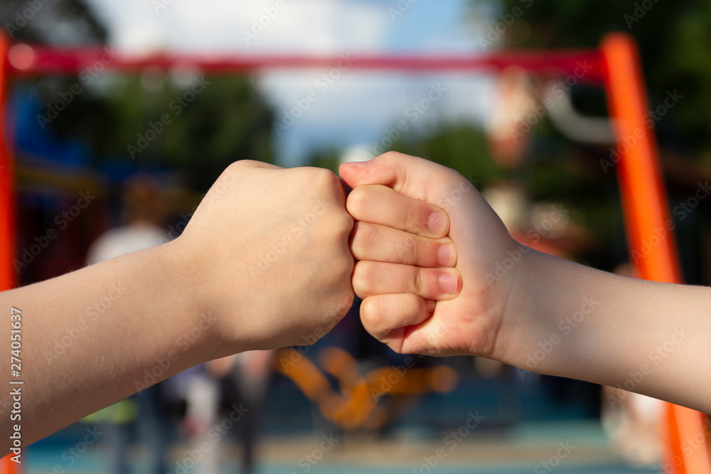 Kids are doing fist bump on the playground.. Stock Photo | Adobe Stock