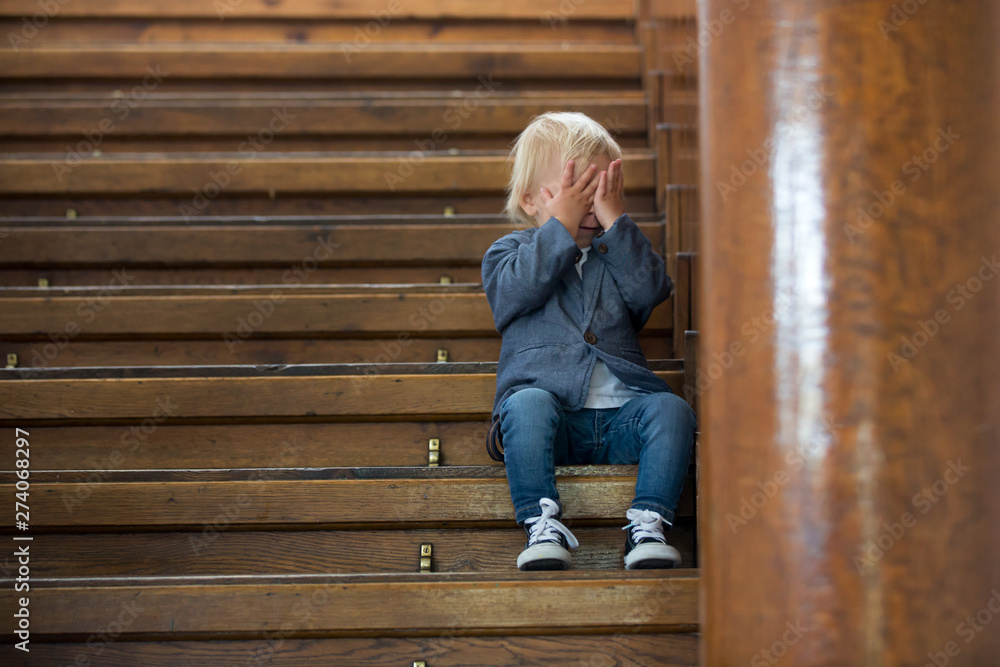 Sad child, sitting on a staircase in a big house, concept for bullying ...