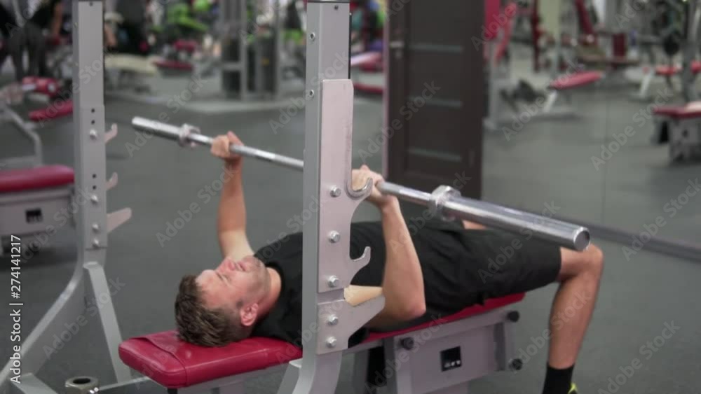 Video Stock A man shakes his muscles in the gym. A man raises the neck ...
