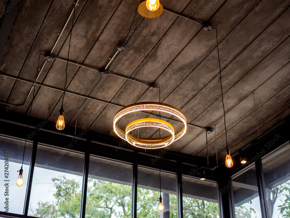 Modern ceiling light and light bulbs hanging from wooden ceiling in ...