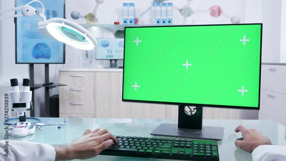 Male doctor hands working on mock-up green screen computer in high end ...
