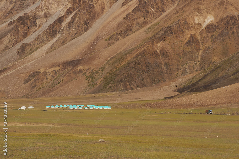 Manali to Leh mountain road. Tented tourist camp dwarfed by mountains ...