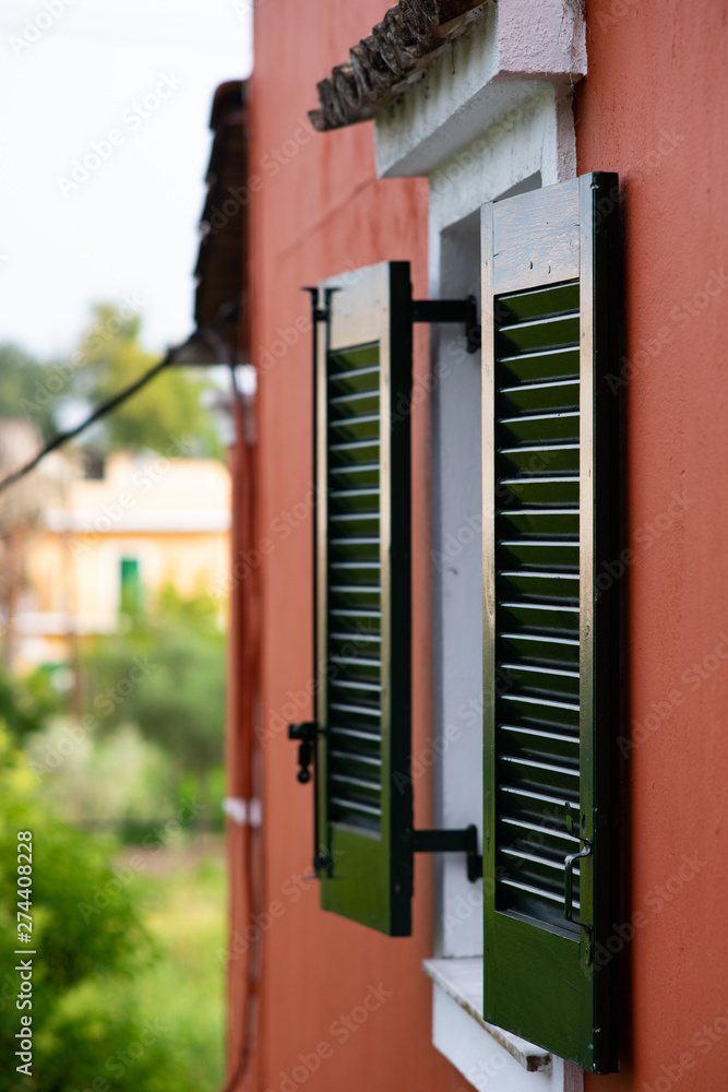 Traditional dark green vintage louver on the windows window blinds in a ...