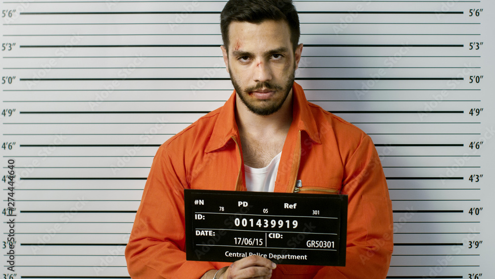 In a Police Station Arrested Man Getting Front-View Mug Shot. He's ... In a Police Station Arrested Man Getting Front-View Mug Shot. He's ...