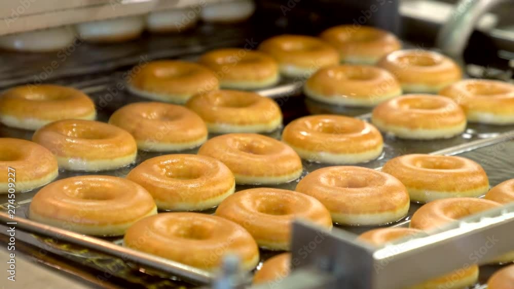 This video shows delicious hot and fresh donuts cooking in oil on ...
