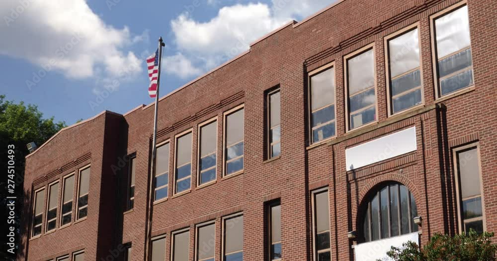 A daytime summer establishing shot of a typical two-story red brick ...
