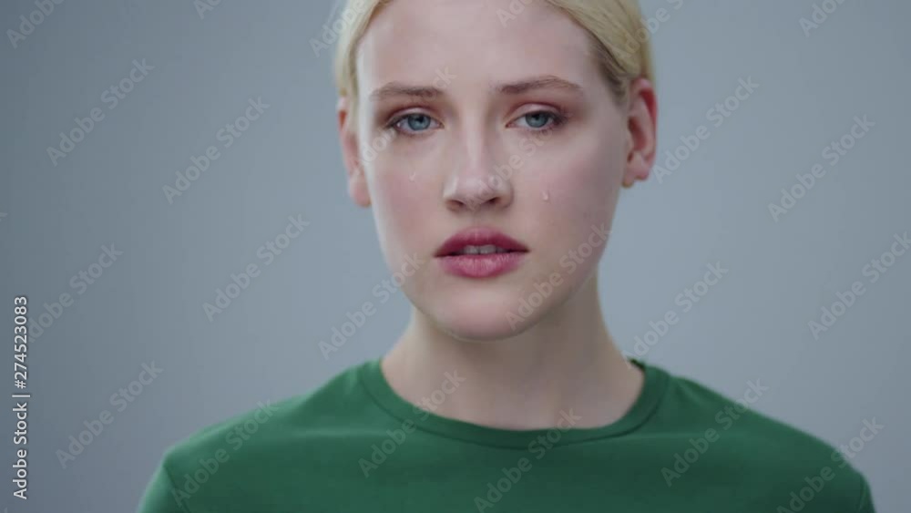Charming young blonde lady in green outfit showing sadness and failure ...