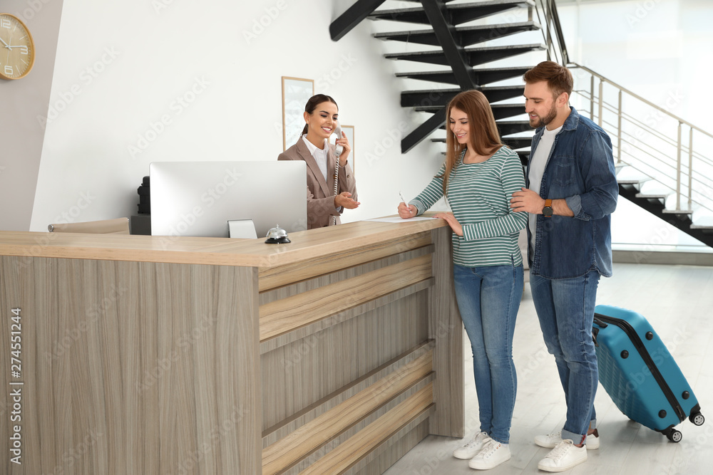 Professional receptionist working with clients at desk in hotel Stock ...