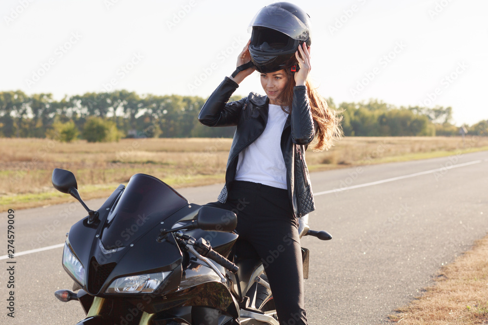 Image of beautiful slender young risk taker sitting on her motorcycle ...