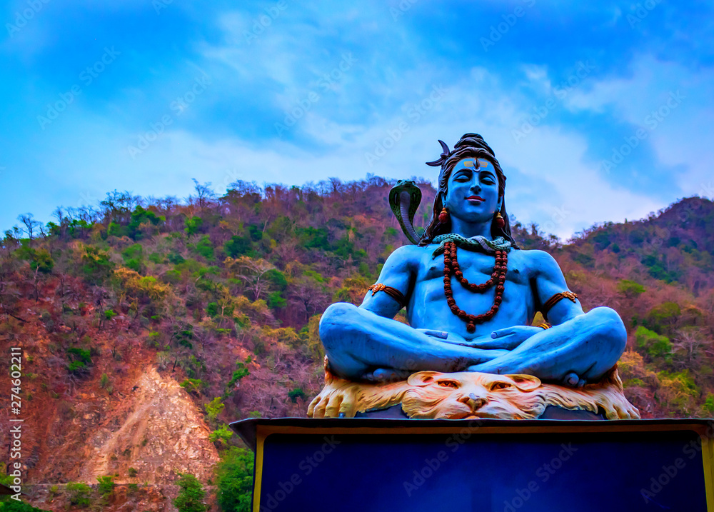 Idol of Indian God Shiva, at the bank of river Ganga in Rishikesh with ...