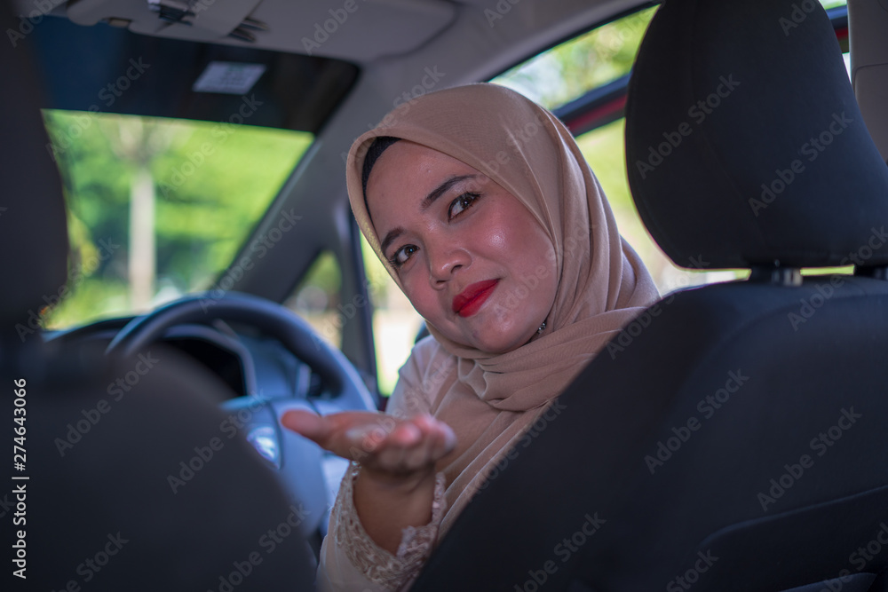 Portrait of young Asian Muslim woman driver, happy woman driving a red ...