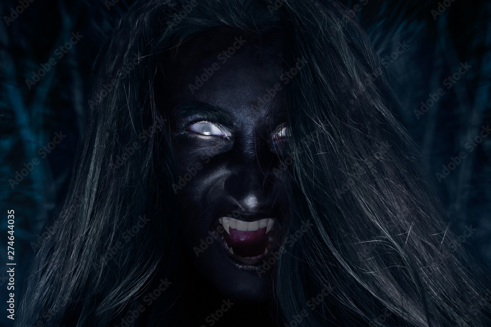 Scary face of silvan witch with dark skin and fangs screaming in night ...