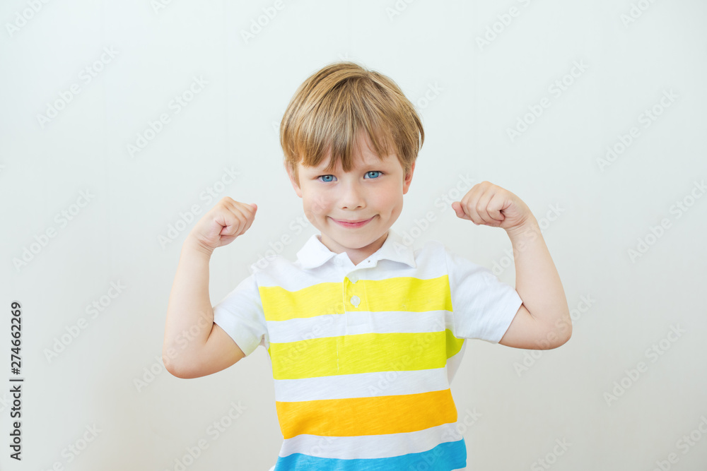 Portrait of a strong kid showing the muscles of his arms on white ...