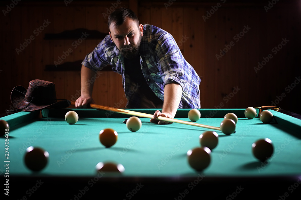A man with a beard plays a big billiard. Party in a 12-foot pool ...
