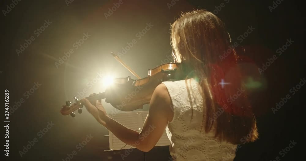 Female asian violinist playing sheet music on stage during concert ...