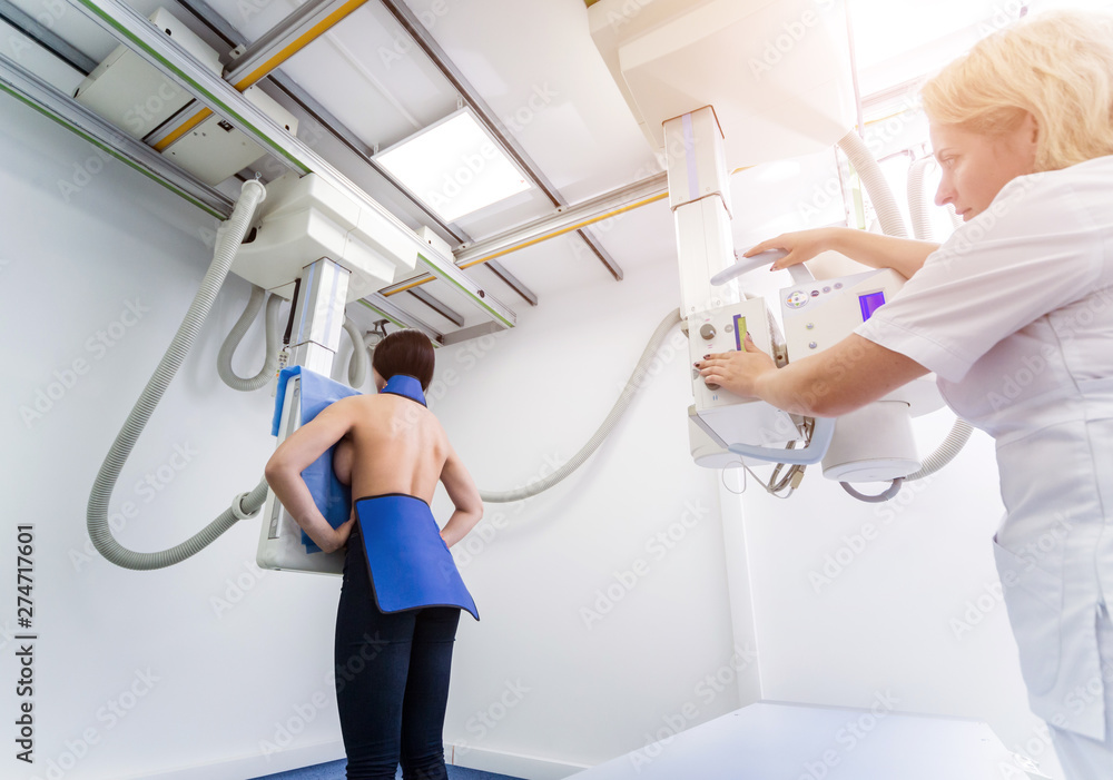 Radiologist and patient in a x-ray room. Classic ceiling-mounted x-ray ...