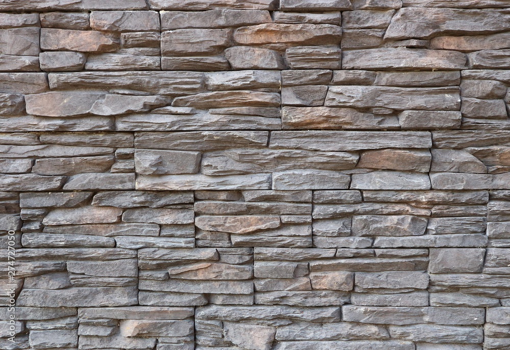 Dark gray and brown exterior wall cladding made of irregular natural ...