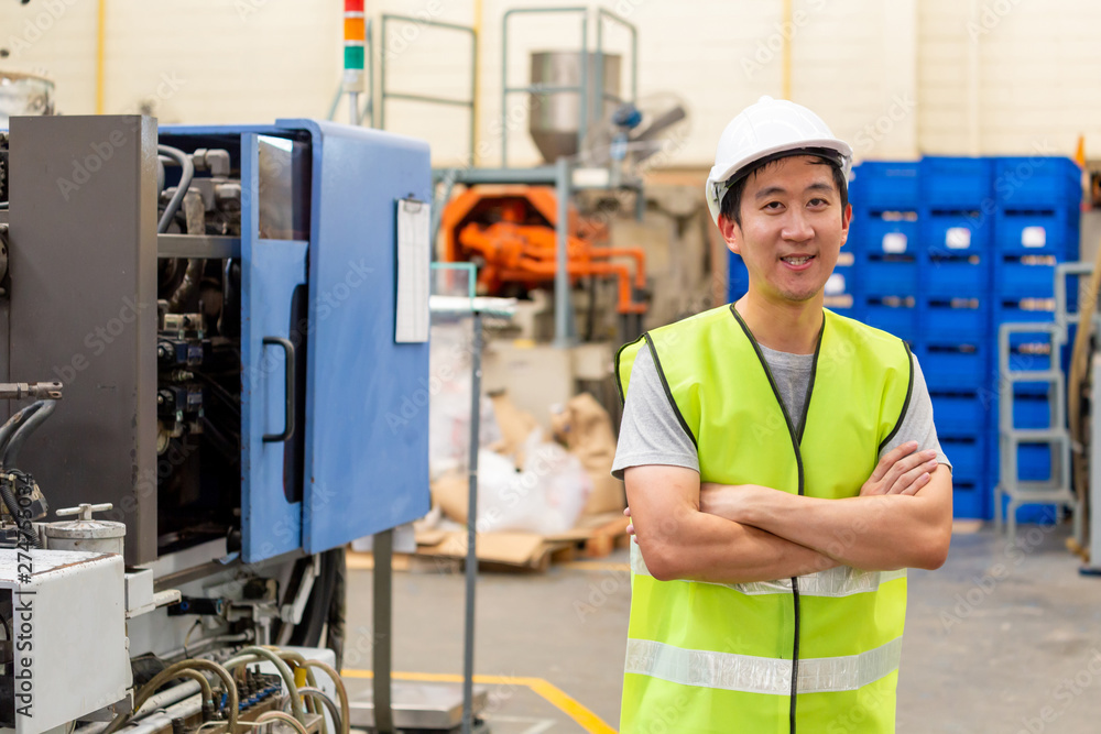 Front view of Asian factory worker with safety hard hat posed looking ...