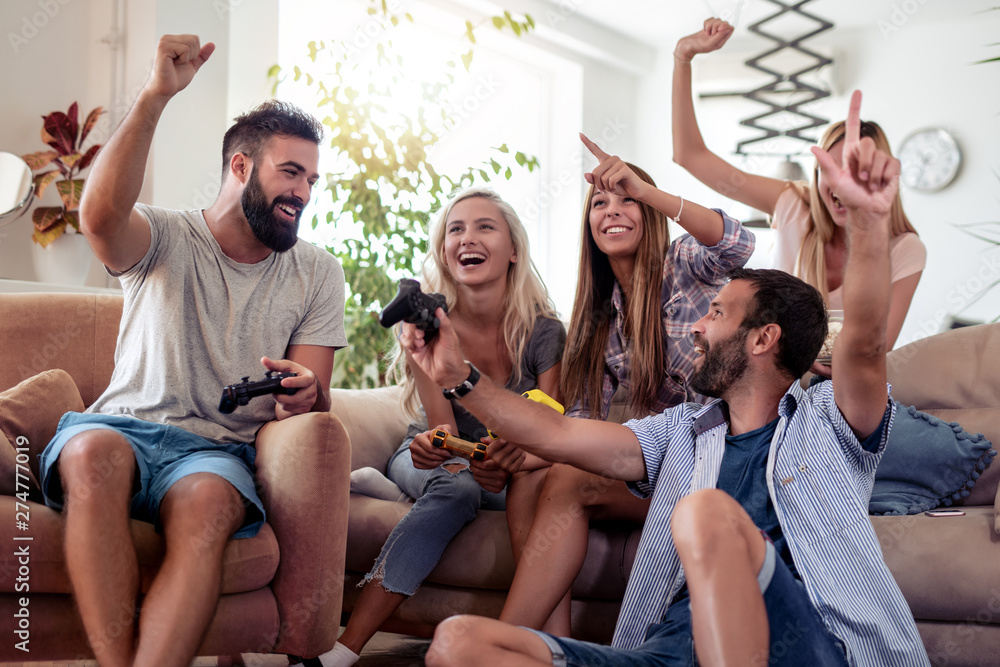 Friends play video games at home Stock Photo | Adobe Stock