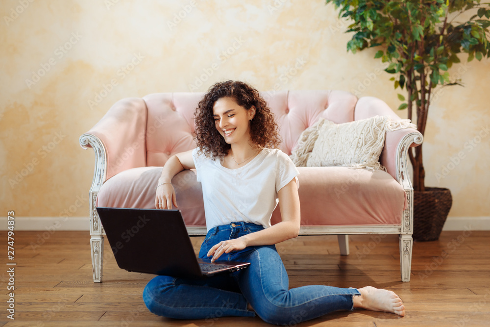 Cute happy young girl working on computer and smiling. Beautiful woman ...
