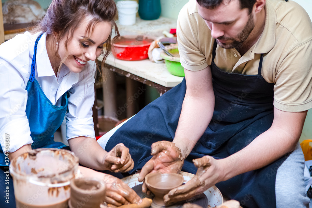 Experienced Male Potter Tutor Working with Female Apprentice with Clay ...