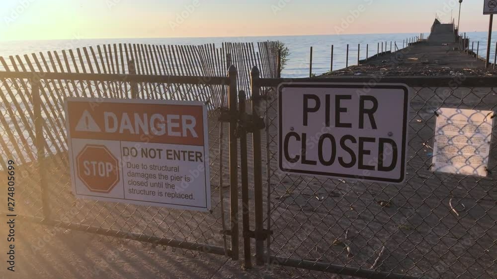 Pier closed signs of danger where a beach is not safe and falling into ...