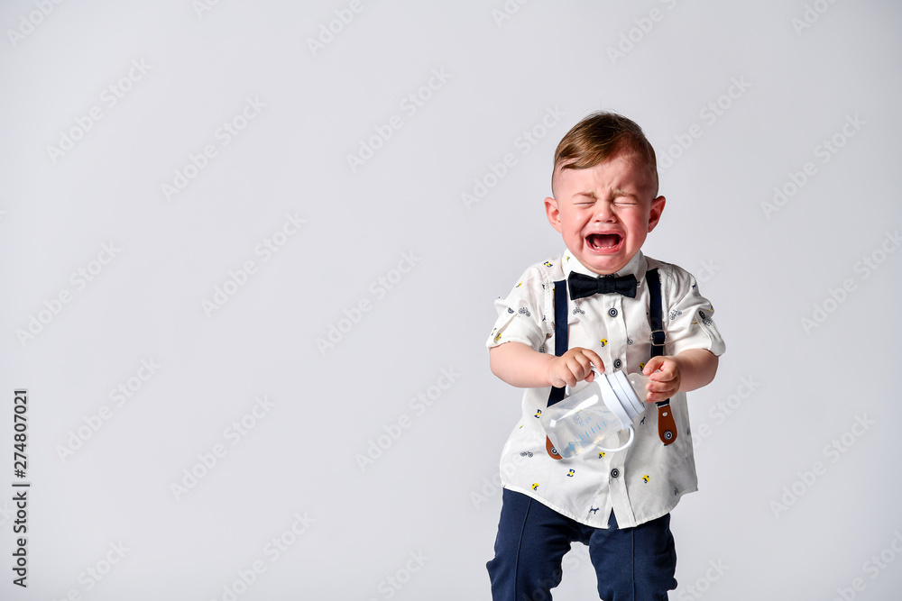 Crying baby. Portrait of a kid in full growth in the studio on a white ...