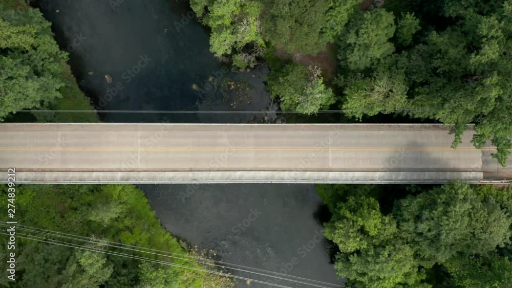 raising top down view of a truck with a boat trailer crossing a bridge ...