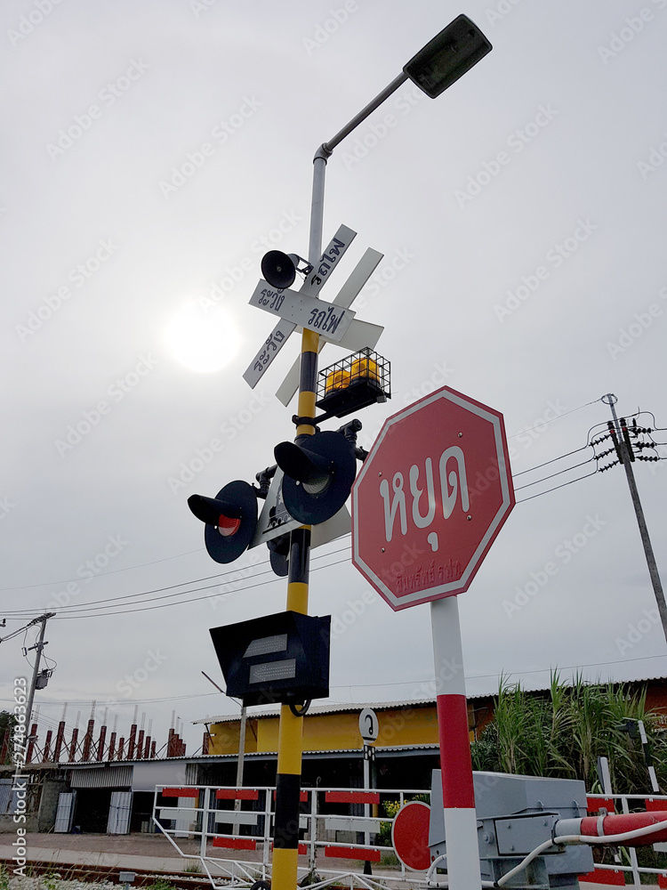 Thai railway crossing with the red stop sign and light signal ...