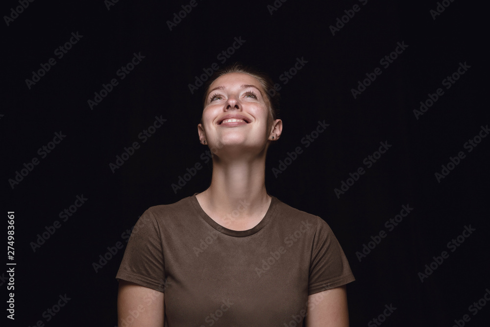 Close up portrait of young woman isolated on black studio background ...