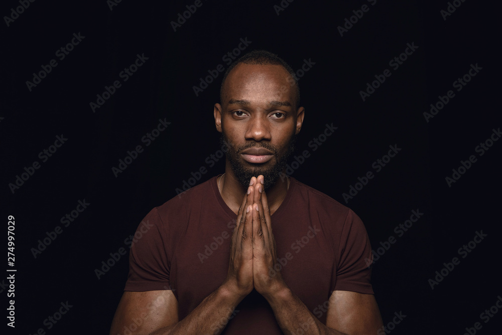 Close up portrait of young man isolated on black studio background ...