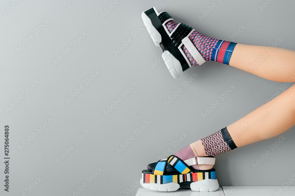 Beautiful female legs in mismatched trendy socks posing in two ...