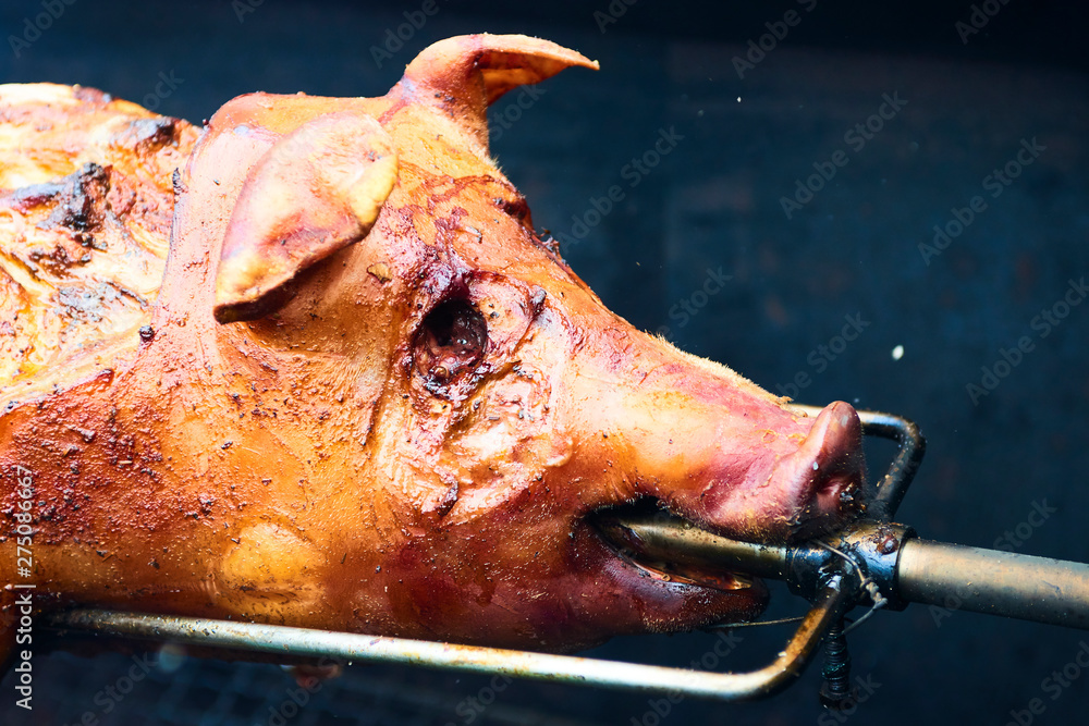A pig grilled traditional coal and fire. The little pig is roasted ...