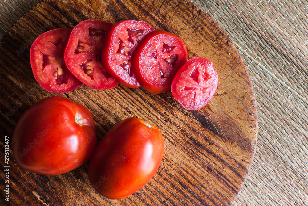 Tomate entero y picado en tabla de cosina Photos | Adobe Stock