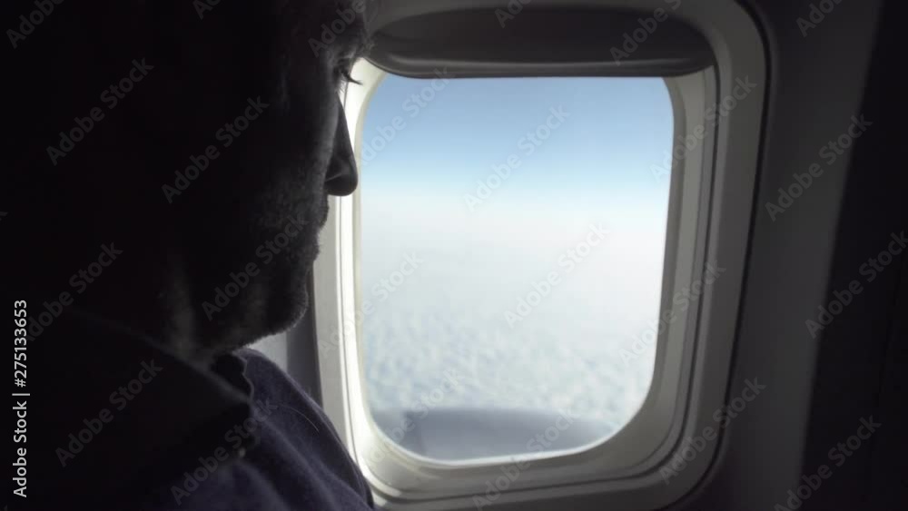 Nervous man afraid of flying on an airplane sitting and looking into ...