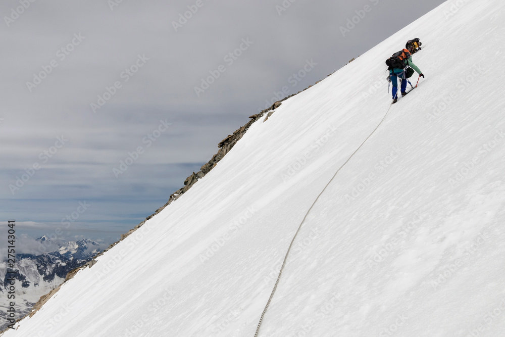 Western Mongolia mountainous landscape. Two climbers climb Khuiten Peak ...