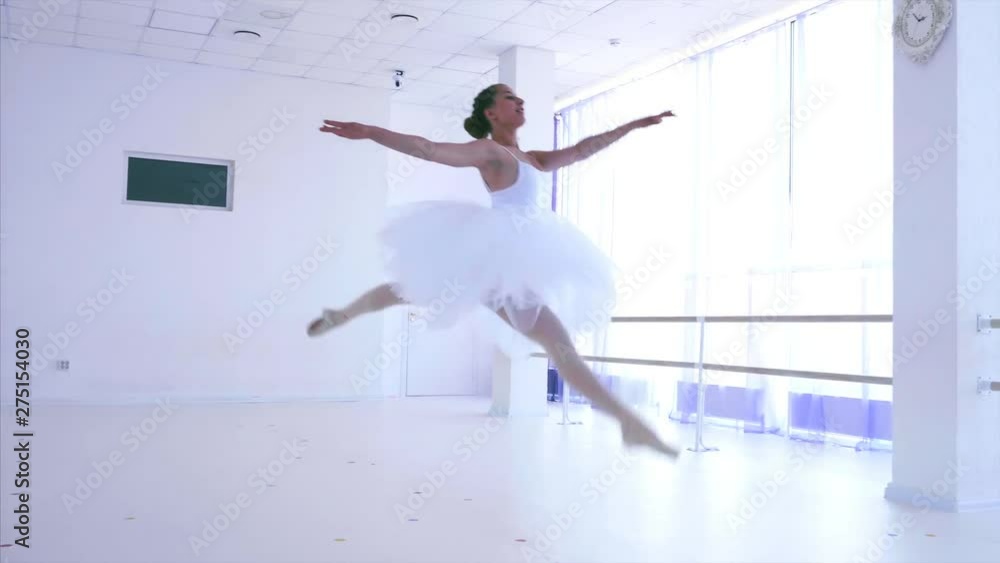 Ballet dancer is jumping up making grand temps leve passe. Classical ...