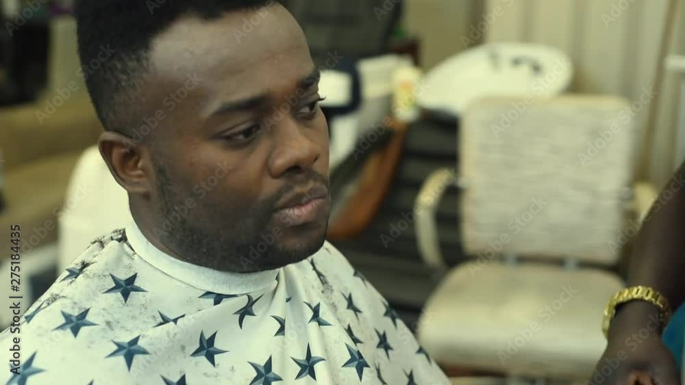 Black man in the african barbershop. Cute black man makes a haircut in ...