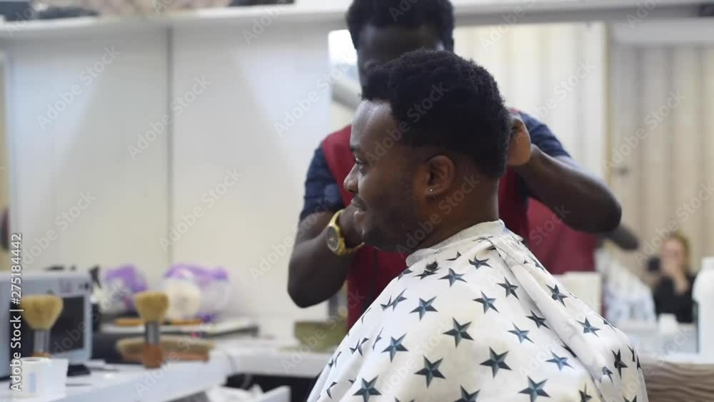 Black man in the african barbershop. Cute black man makes a haircut in ...