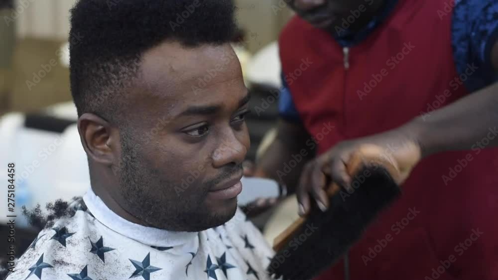 Black man in the african barbershop. Cute black man makes a haircut in ...