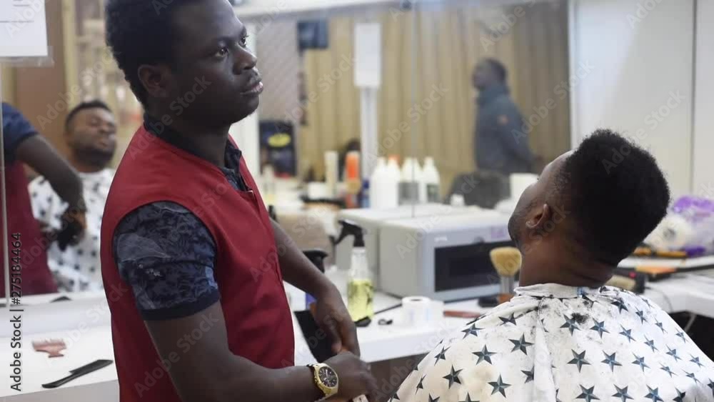 Black man in the african barbershop. Cute black man makes a haircut in ...