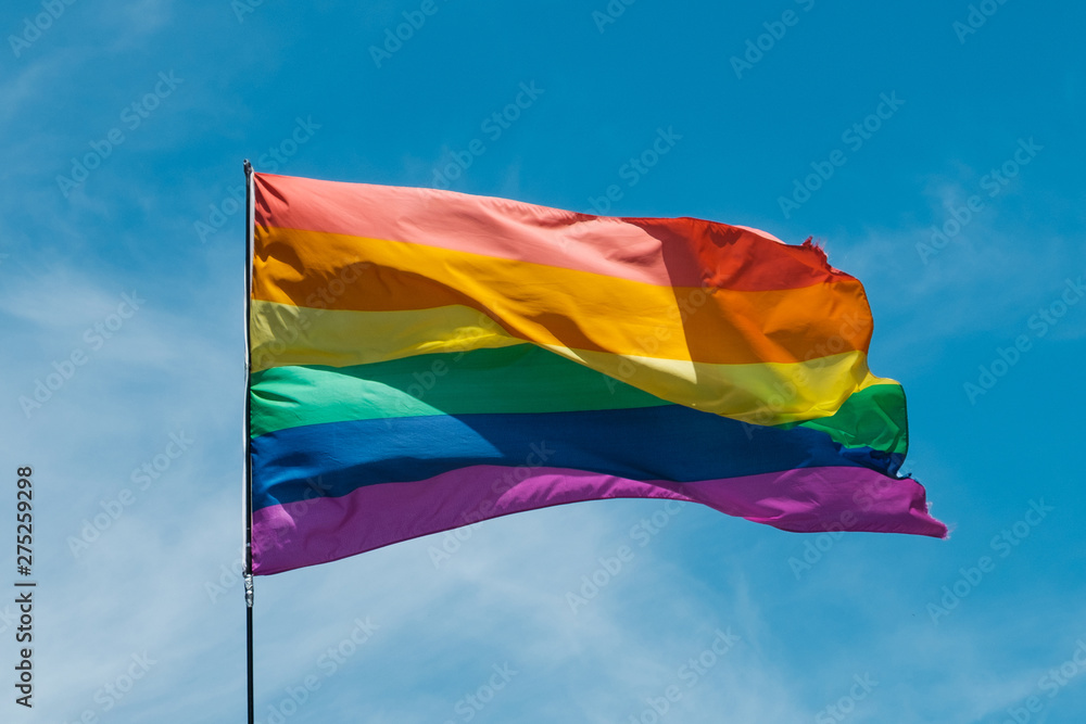 Gay rainbow flag waving with blue sky background - symbol of Gay Pride ...