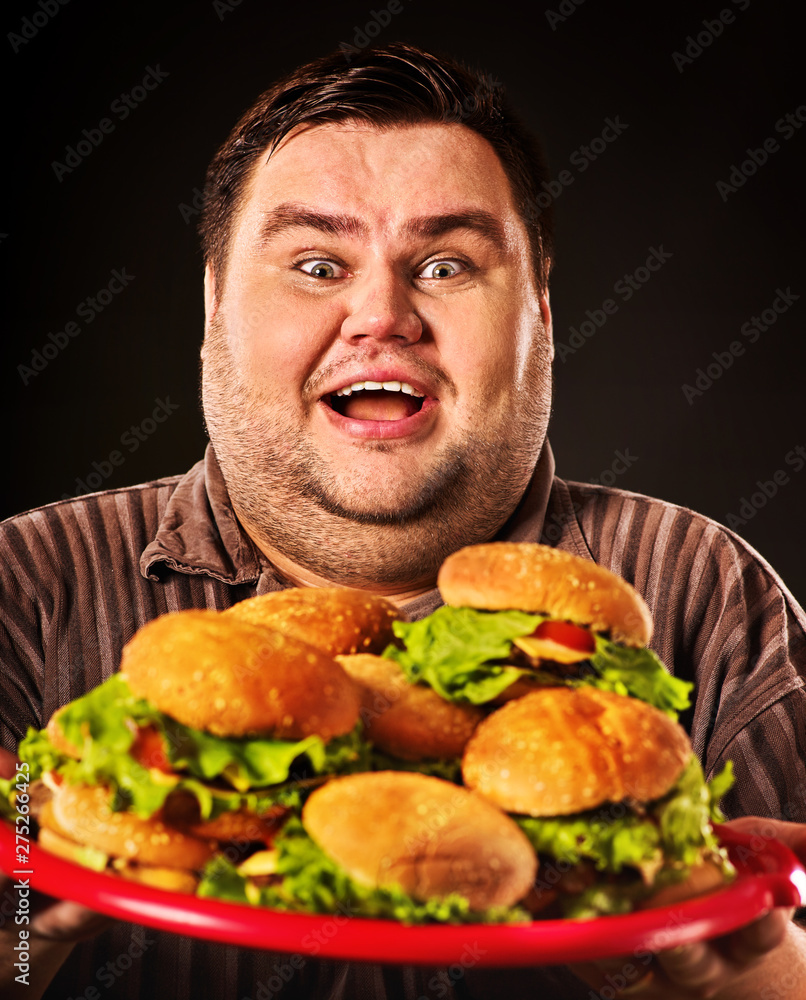 Fat man eats burgers. Obeseness and gluttony of fast food hamburger ...