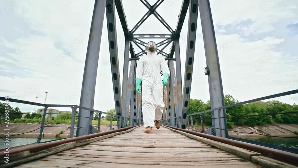 Confident protected young man in special white suit gas mask exploring ...