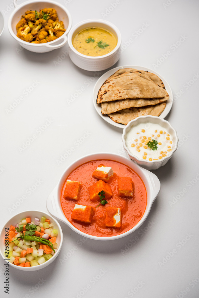 Assorted Indian food like paneer butter masala, dal, roti, rice, sabji ...